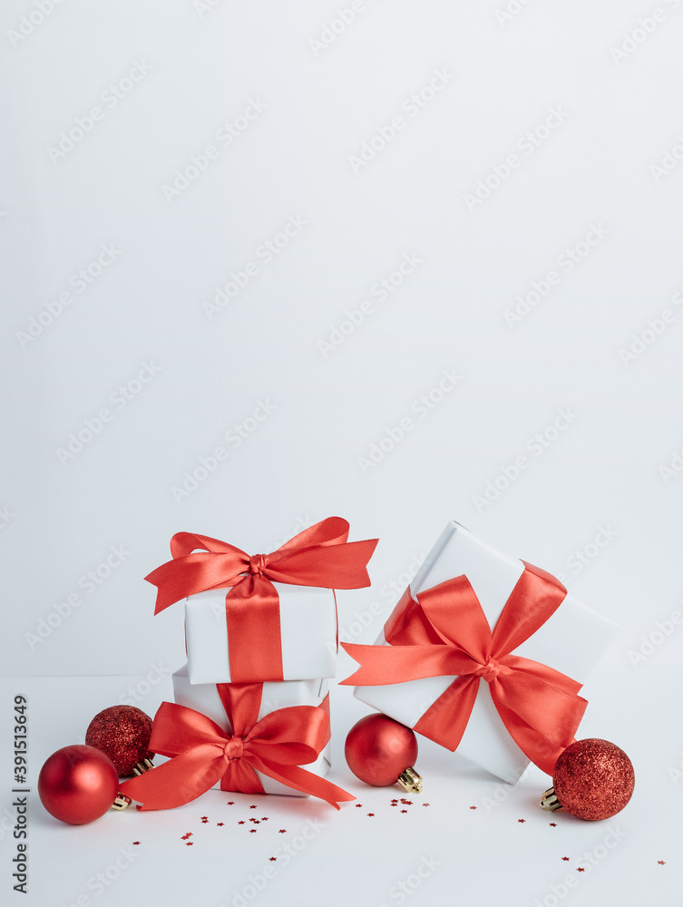 Stack of presents with red ribbon and ornaments balancing on each other ...