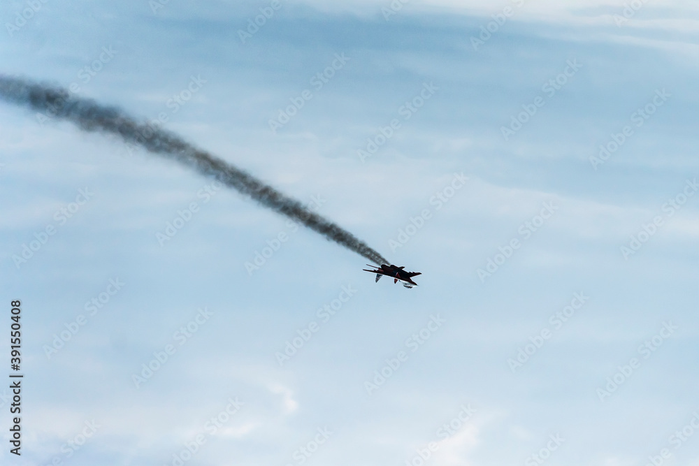 Military fighter jet during a fall on background of blue sky. The plane ...