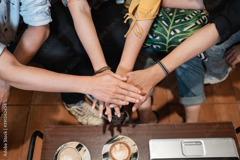 group of friends joining hands with unity teamwork concept when hang ...