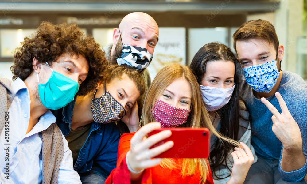 smiling group of people wearing protective face mask posing for a ...
