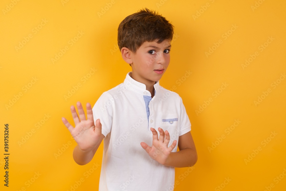 Afraid Cute Caucasian little boy standing against yellow background ...