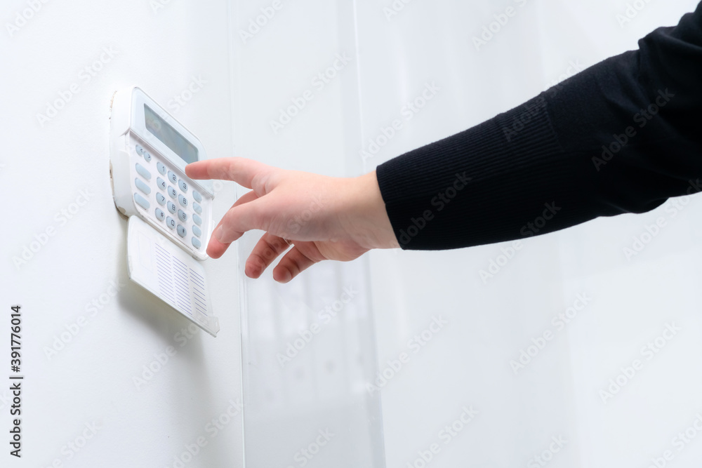 Hand entering alarm system password of an apartment, home or business ...