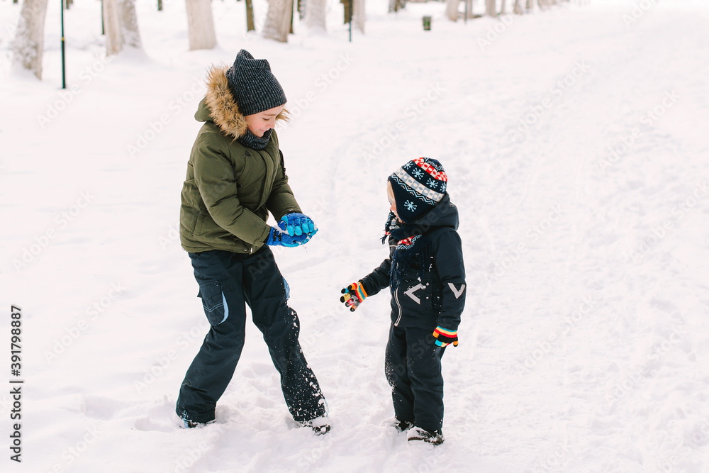 Happy kids playing snowballs game. Children play with snow in the ...