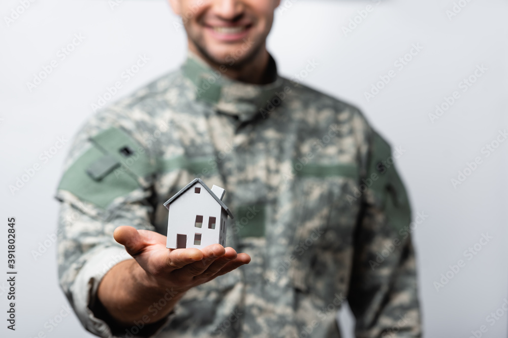 house model in hand of happy military man in uniform on blurred ...