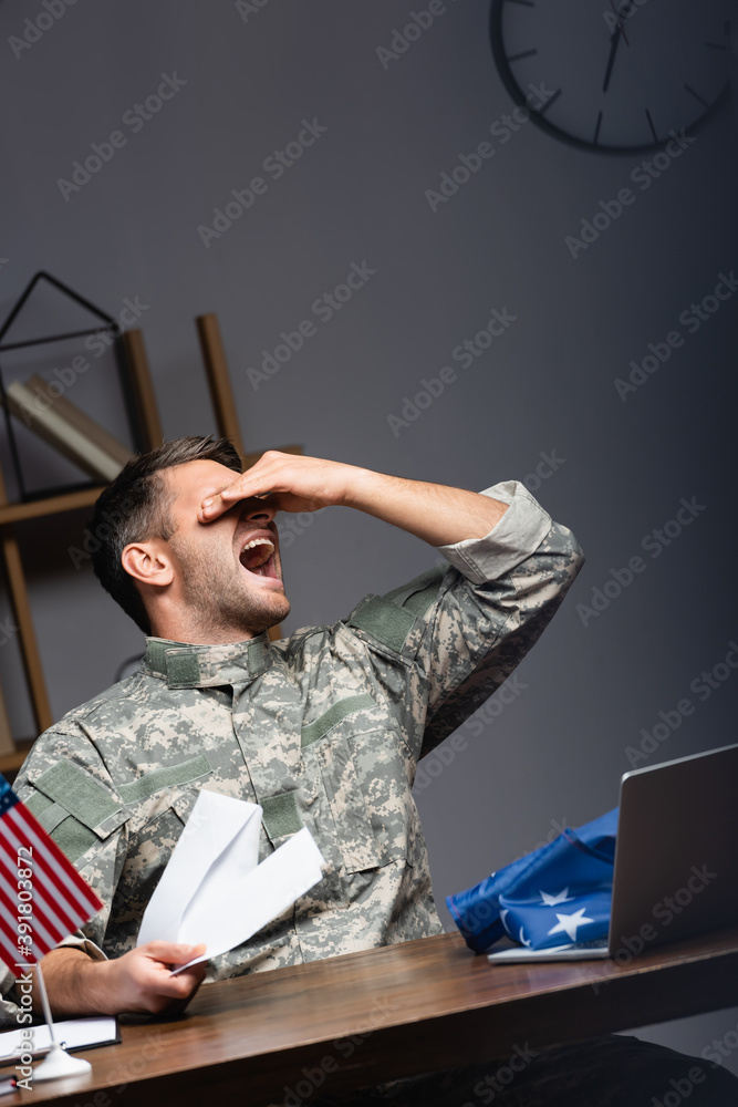 angry military man in uniform covering eyes and holding letter while ...
