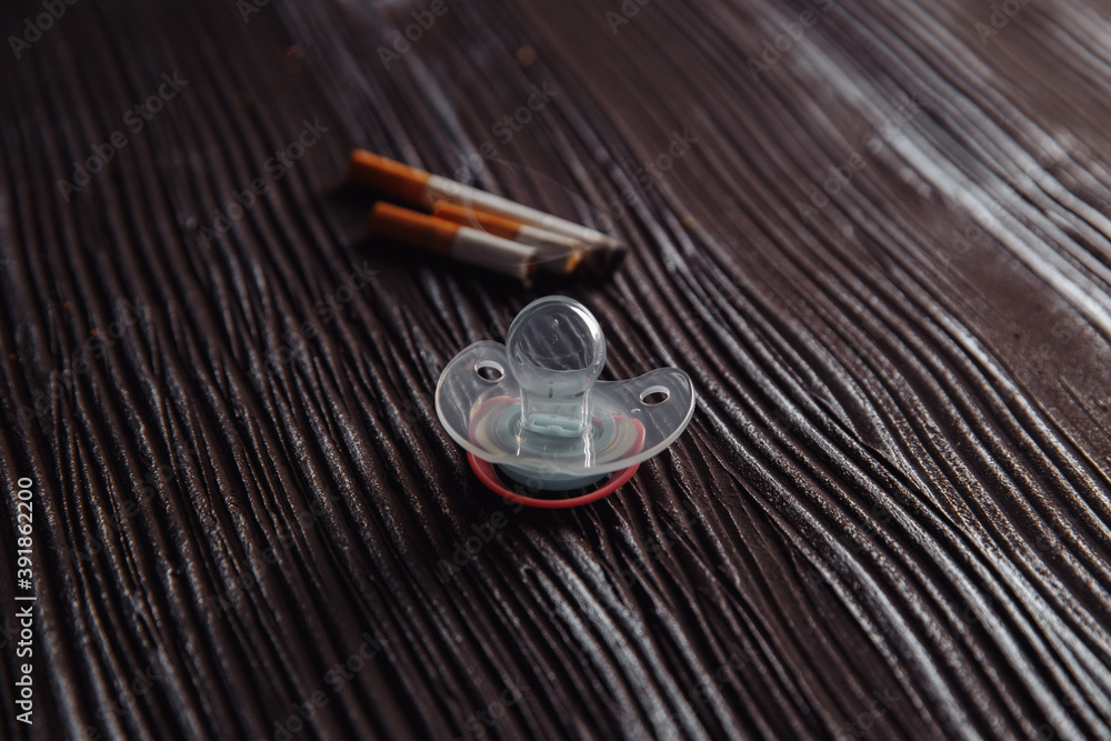 Cigarette and baby pacifier as a symbol of maternity and smoking. foto ...