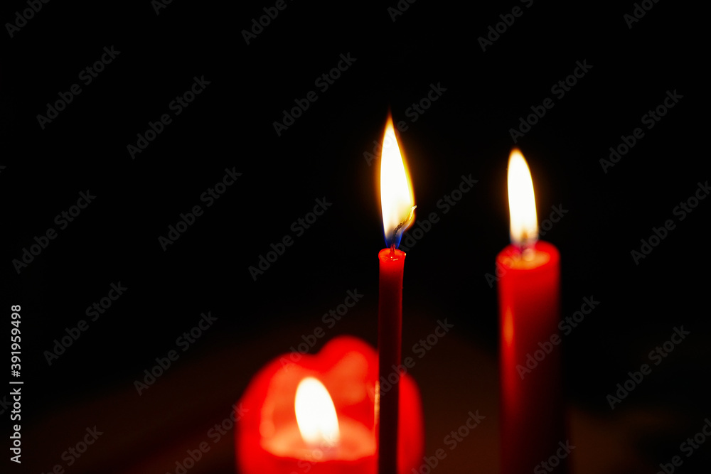 3 red ritual candles on dark isolated background. Burning church ...
