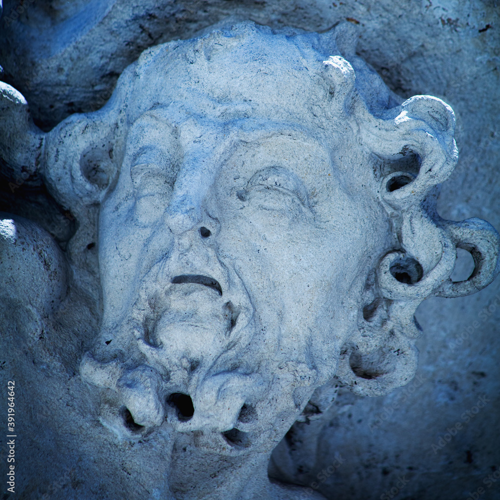 Stockfoto med beskrivningen Ancient stone statue of Sisyphus face. God ...