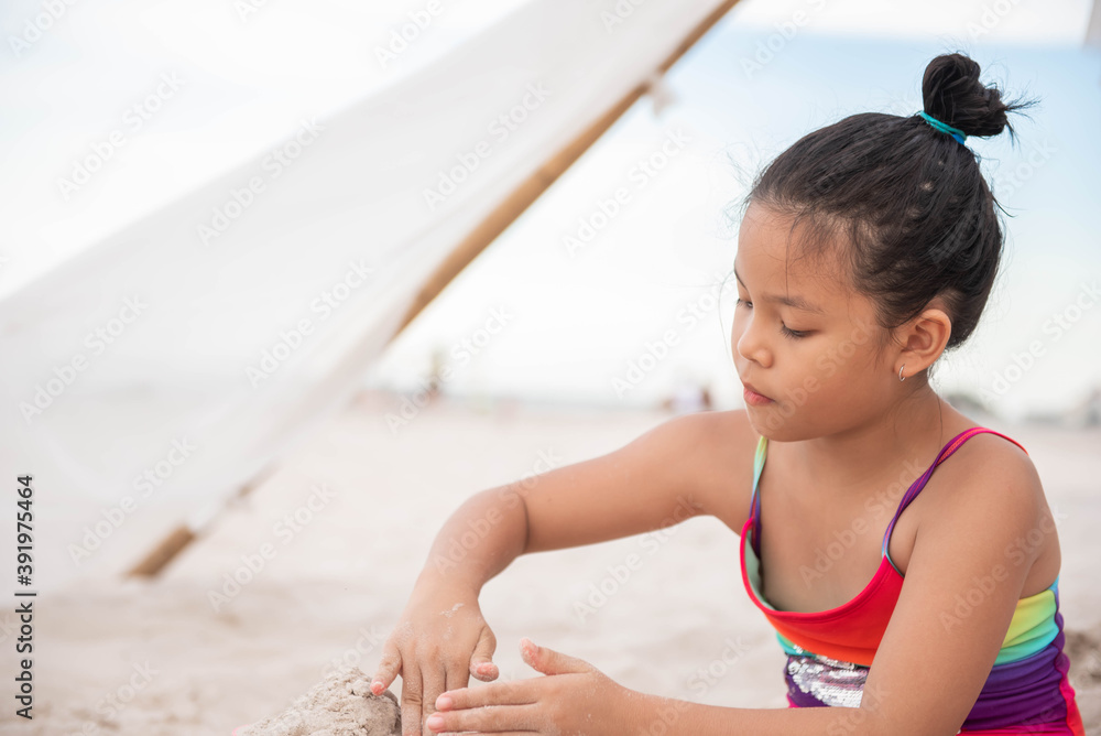 cute little girl playing on the beach on summer holidays. Happy child ...