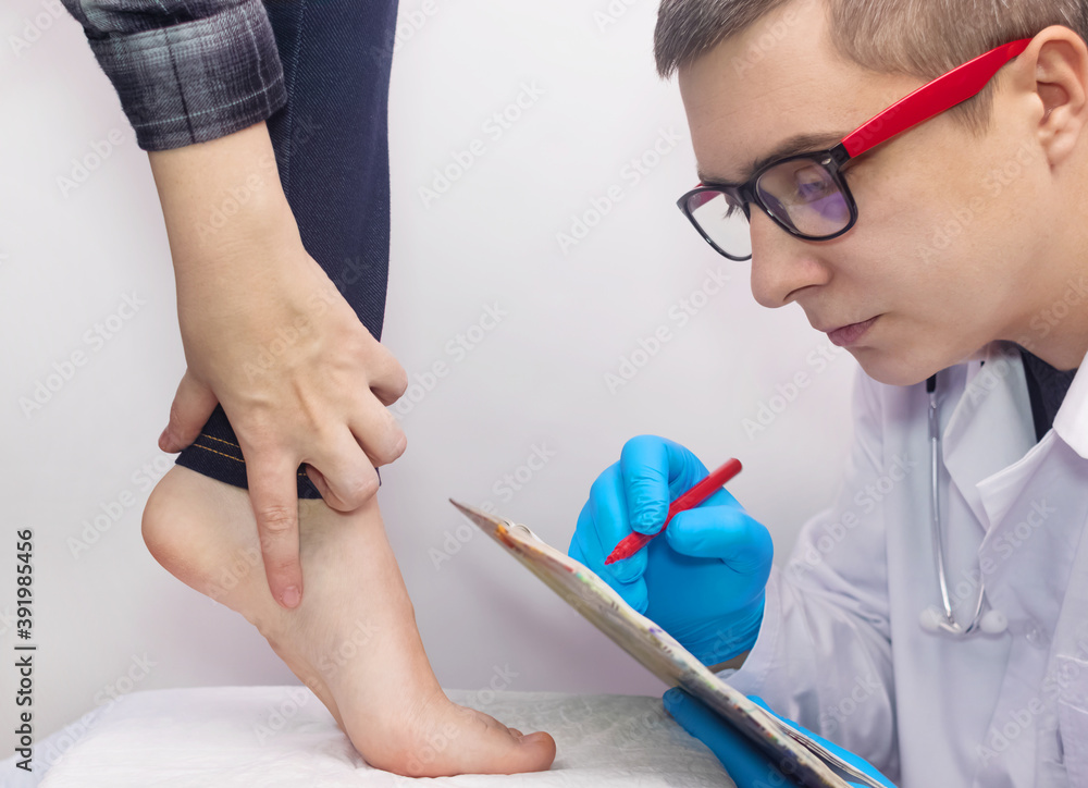 An orthopedic surgeon examines a woman's leg. Foot pain, tendon sprains ...