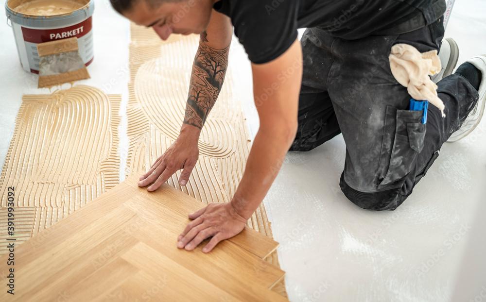 talentierter Bodenleger auf der Baustelle verlegt einen Dreischicht ...