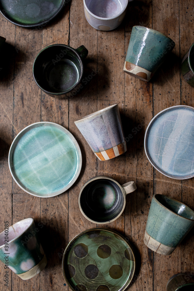 Selection of ceramic mugs, cups, and plates on wood surface Stock Photo ...