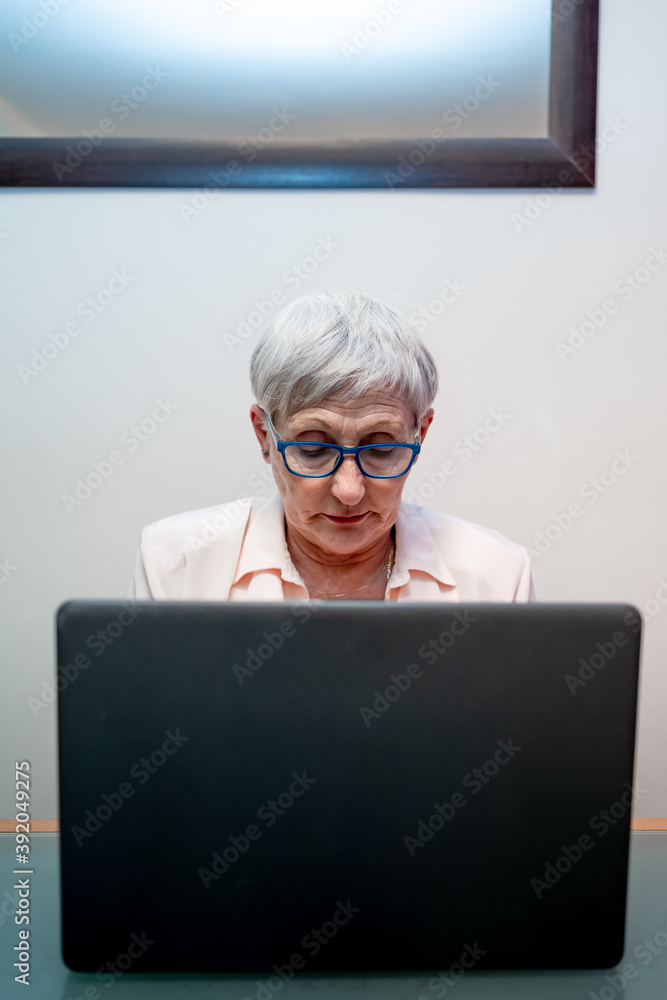 Caucasian older woman white hair and blue glasses with a laptop Stock ...