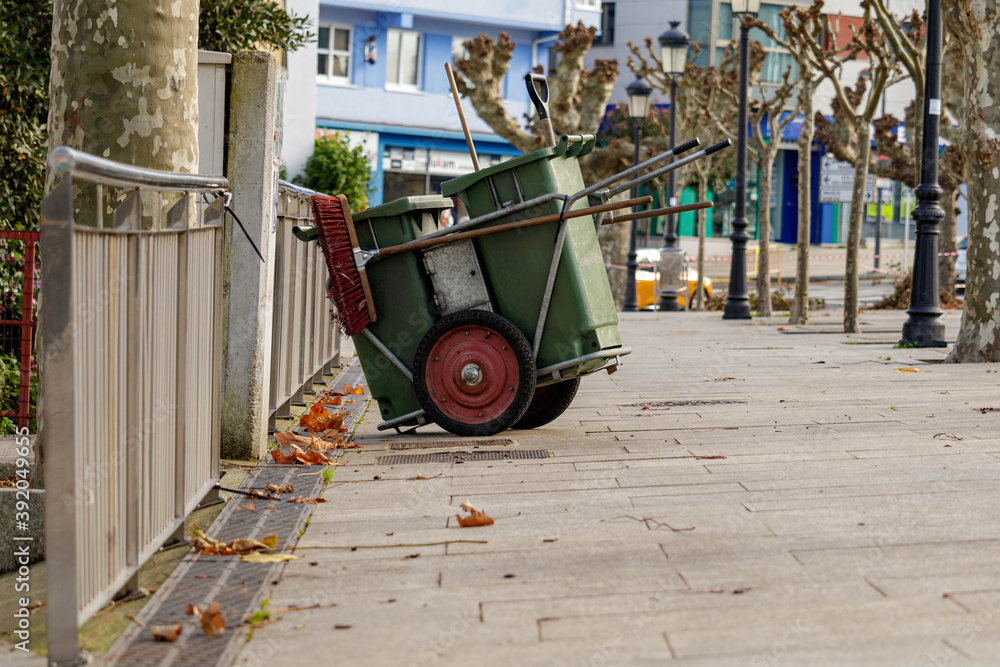 Street sweeper cart with broom left at the side of the road in Cambre ...