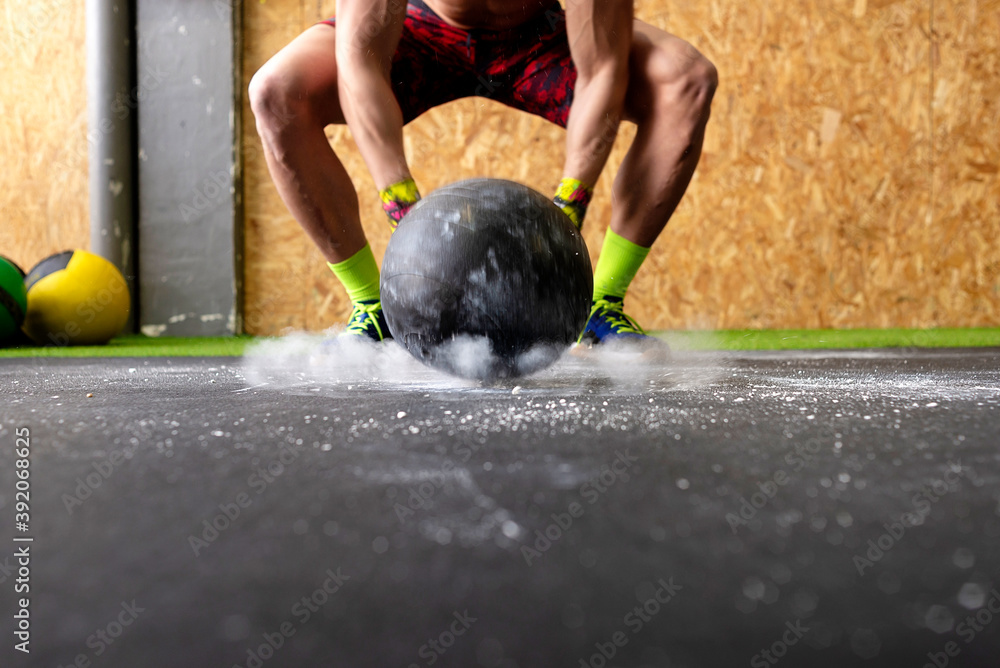Powerful shirtless male throwing heavy ball against ground during ...
