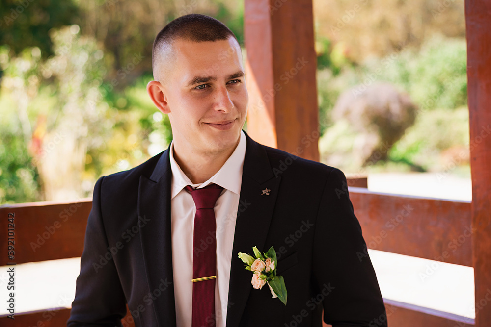 Young groom poses for the first time on camera. Wedding photosession of ...