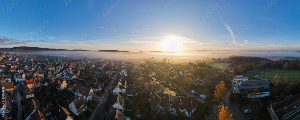 Aerial view of sunrise above foggy town. Mystical fog scattering ...