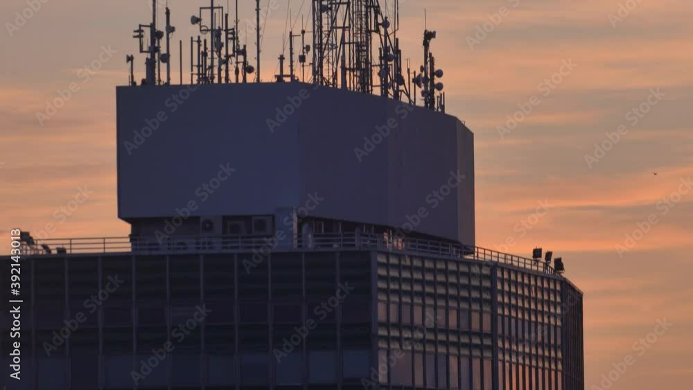 Multiple Broadcasting Antennas on top of High Rise Building at Sunrise ...