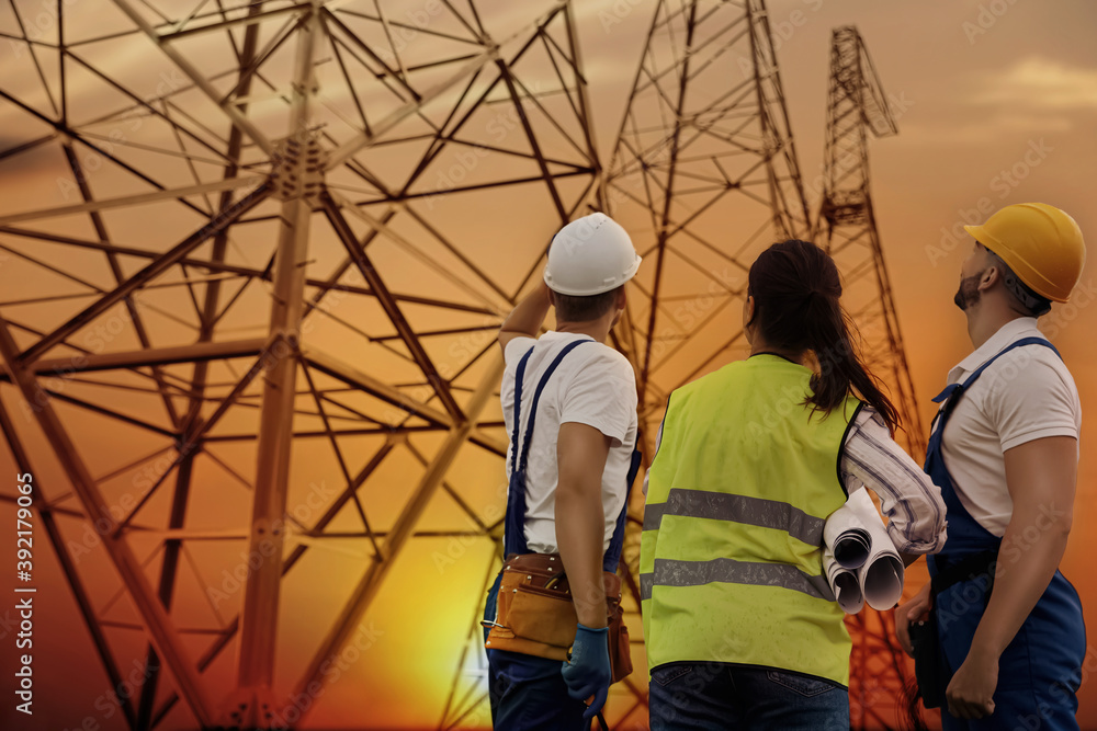 Professional engineers working on installation of electrical substation ...