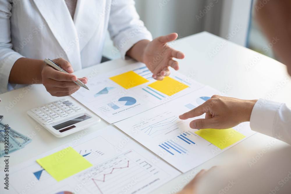 A group of professional business people sit on a meeting table in the ...