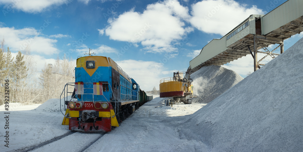 Mining excavator loads rubble into freight railcars in the mining ...