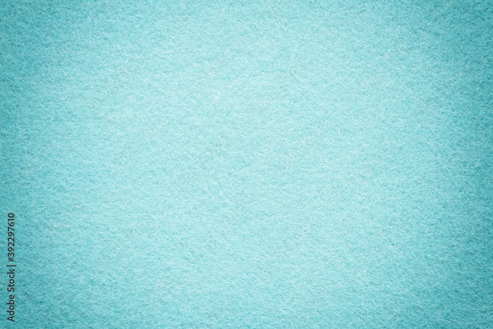 Abstract background of light cyan felt material with vignette ...