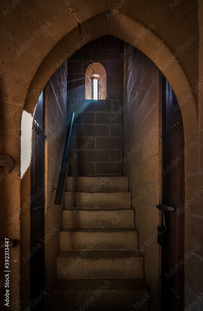 Loophole on an ancient castle, beautiful scene of stair with a ray of ...