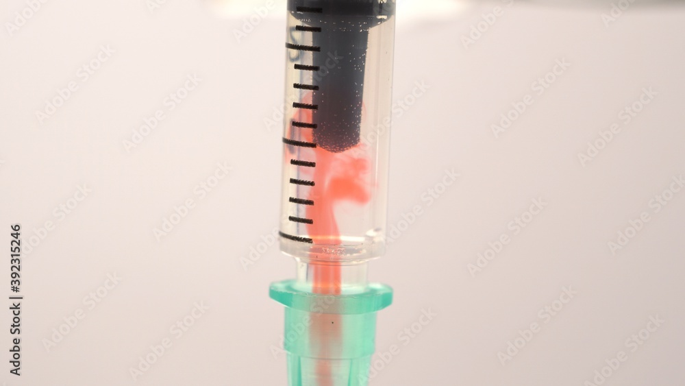 Syringe close up taking mixing blood of a patient with drug and ...
