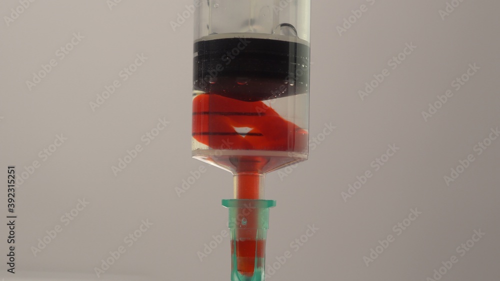 Syringe close up taking mixing blood of a patient with drug and ...