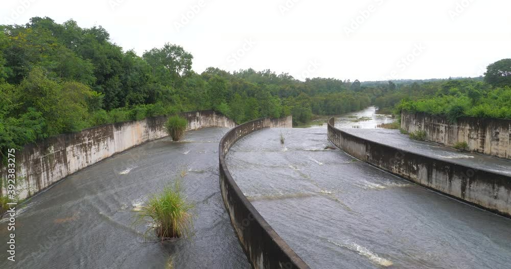 Plenty of water falling from the concrete reservoir dam spillway ...