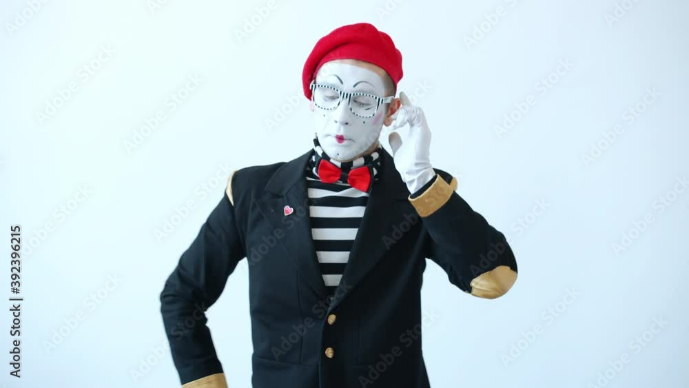Portrait of emotional mime artist chatting on imaginary mobile phone ...