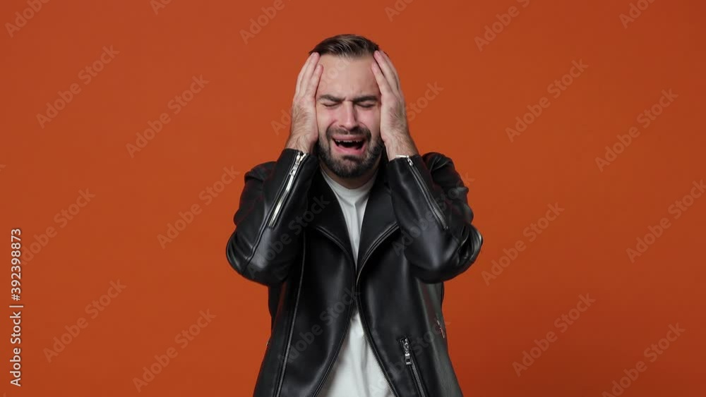 Vidéo Stock Crying worried young bearded man 20s wearing black leather ...