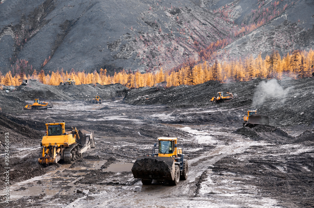 Bulldozers and wheel loaders at work. Mining. Bulldozers cut the ...