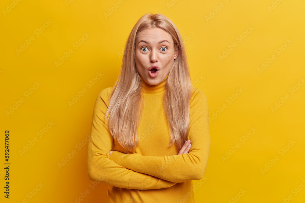 Waist Up Shot Of Surprised Blonde Young Woman Keeps Mouth Opened