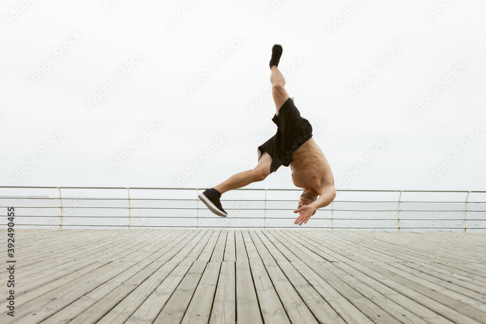 Muscular man doing a head jump upside down without touching his hands ...