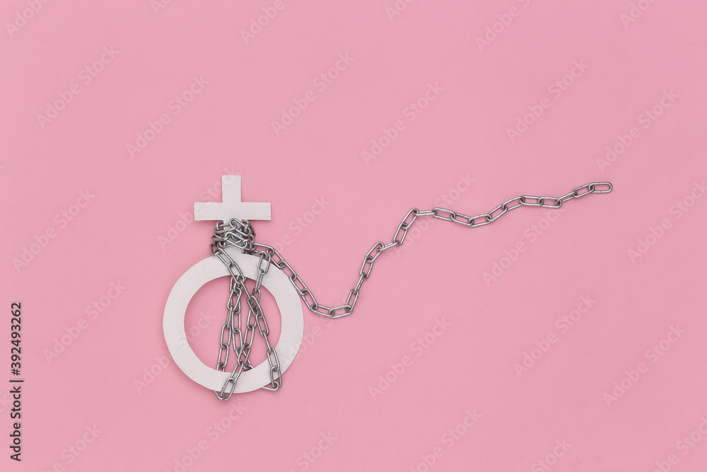 Gender female symbol wrapped in a steel chain on pink background ...