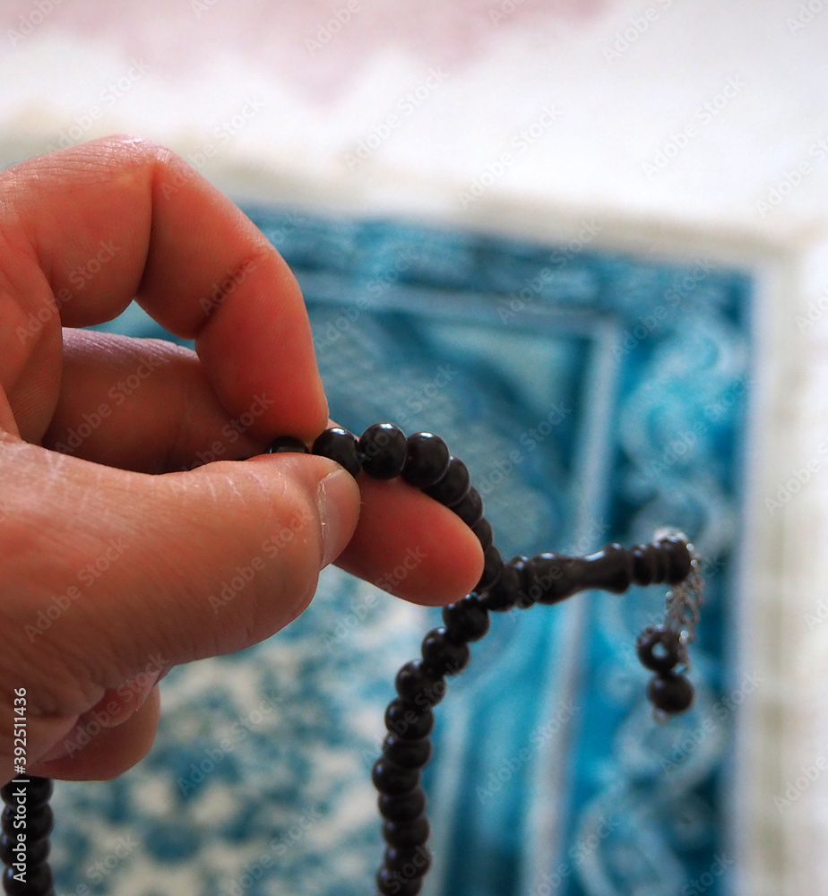 a muslim praying by drawing a rosary, a muslim drawing a close-up ...