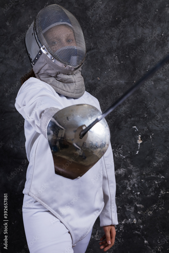 Teenage girl fencer dressed in uniform with epee and helmet Stock Photo ...