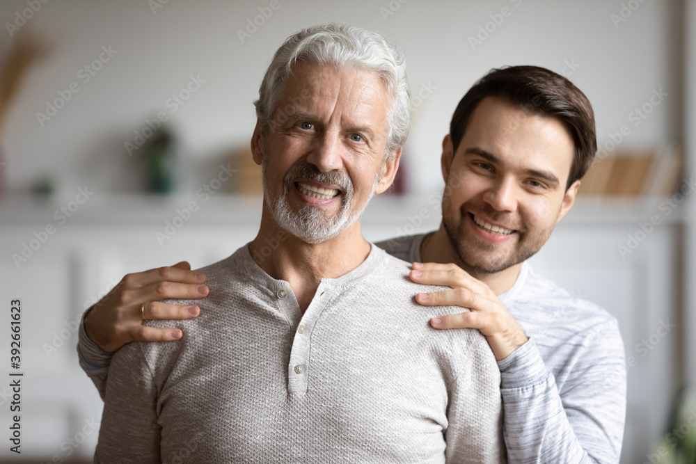 Head Shot Portrait Adult Son Hugging Mature Father From Back Standing