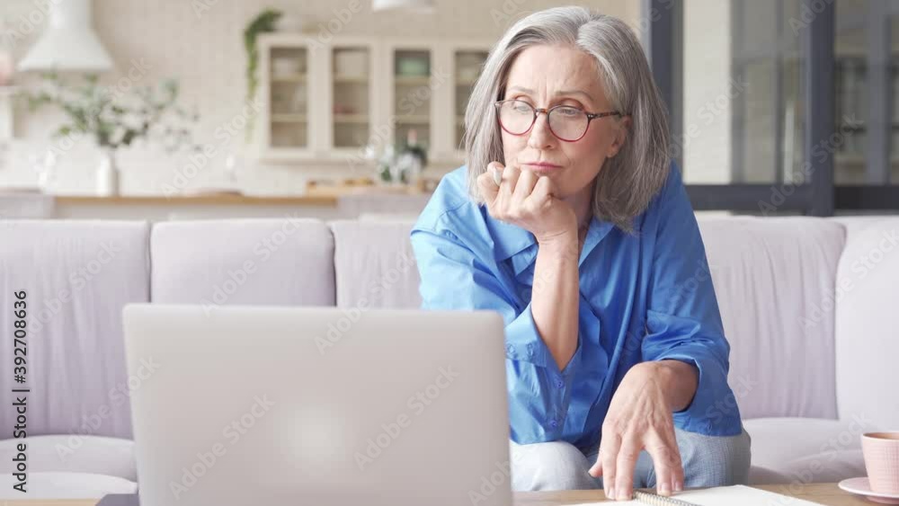 Middle aged senior older woman elearning online concept, watching ...
