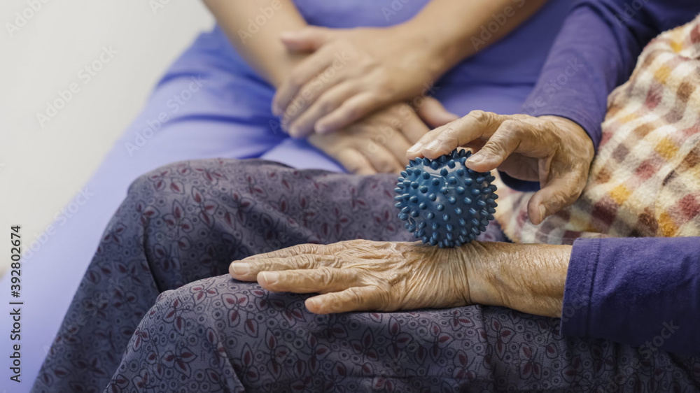 Elderly woman doing rubber ball for exercise fingers, palm ,hand and ...