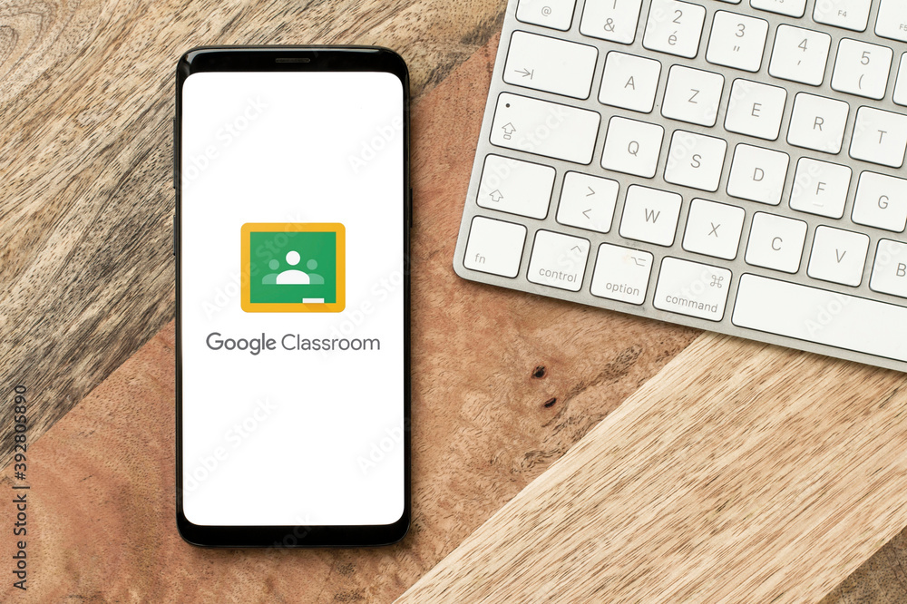 Google Classroom mobile app with keybooard and wooden desk background ...