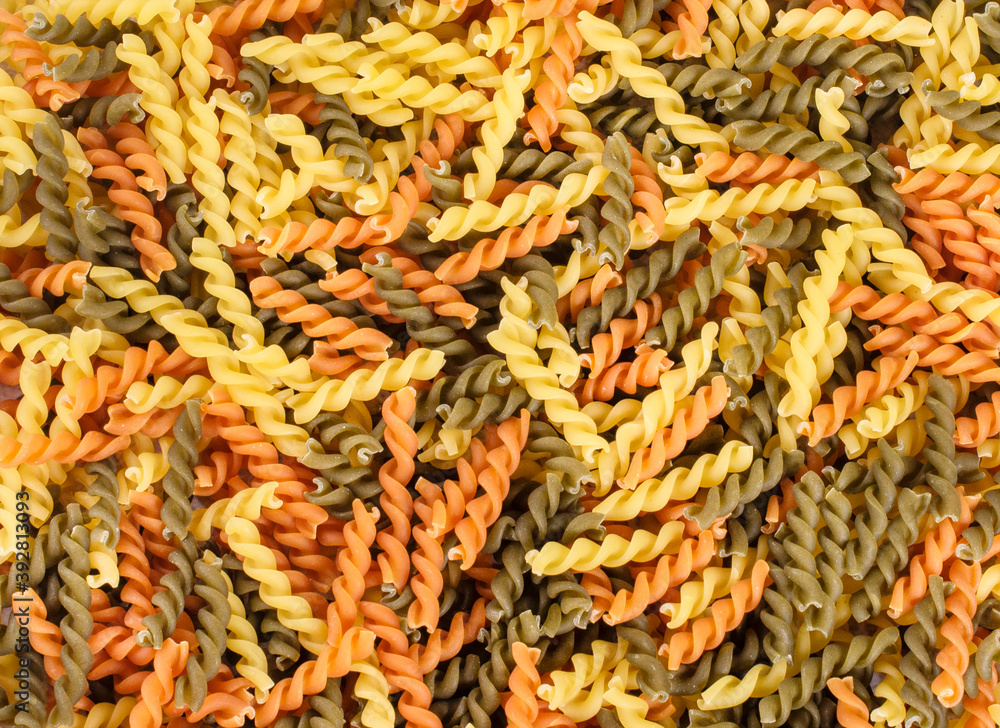 Dry pasta fusilli. Fusilli have spiral shape and yellow , green, orange ...