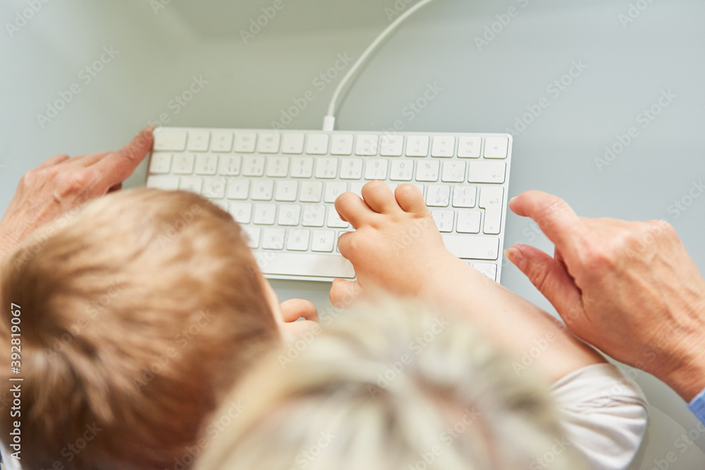 Adult helps child at the computer Stock Photo | Adobe Stock