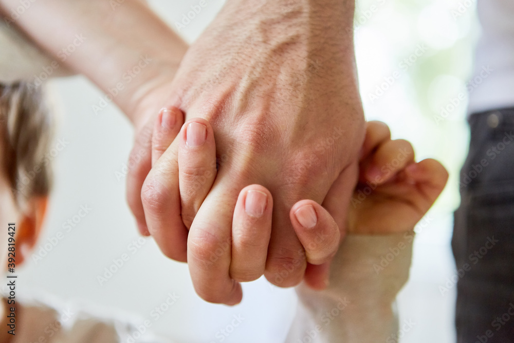 Parents hold hands with child in background Stock Photo | Adobe Stock