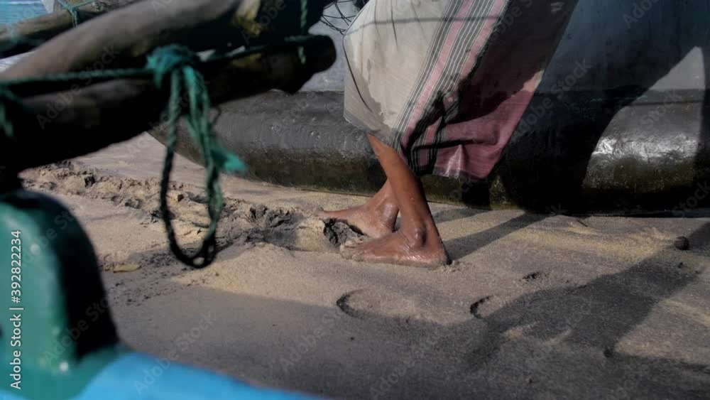 slim dark skinned man legs clump in clean beach sand pulling heavy ...
