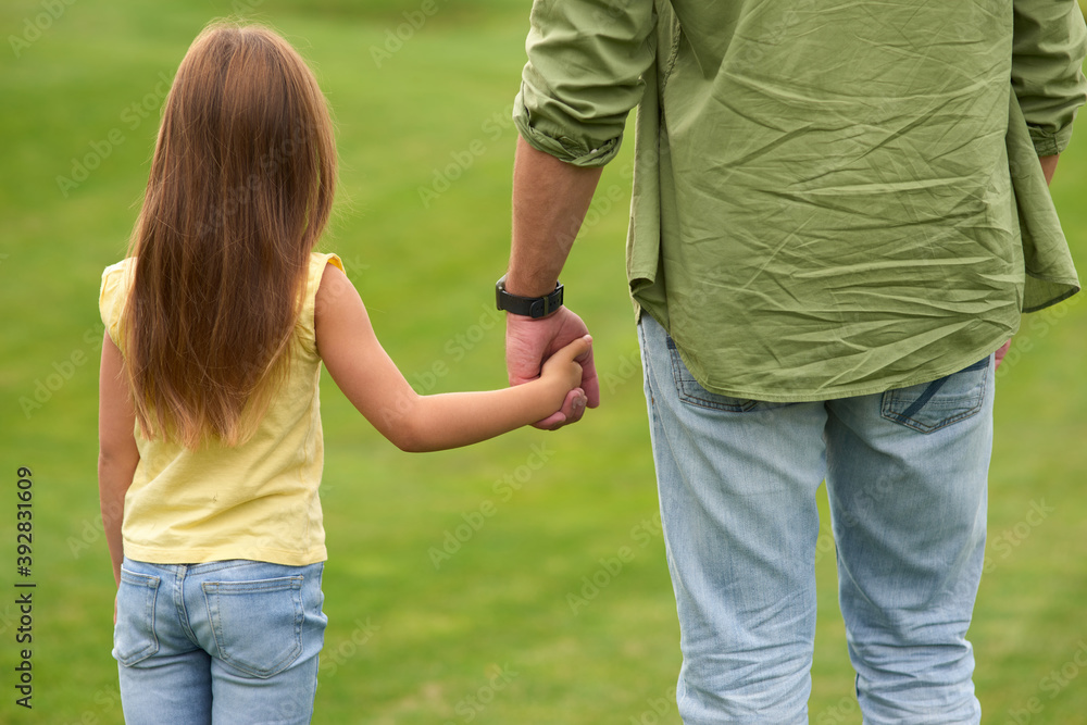 Foto de Rear view of little girl and her father holding each other ...