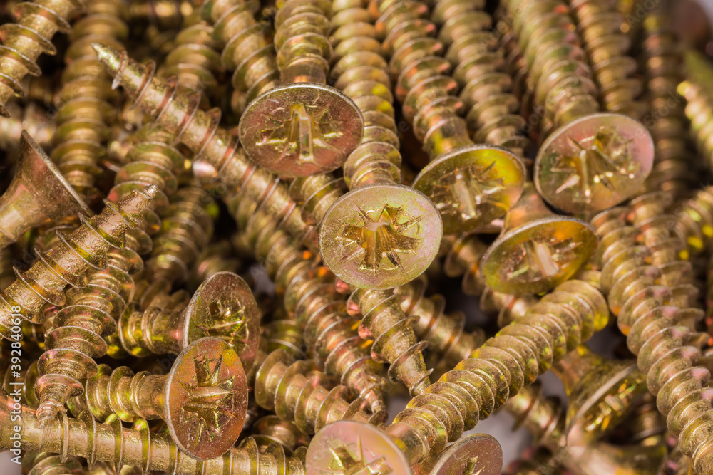 Cross recessed tapper screws with yellow corrosion coating, close-up ...