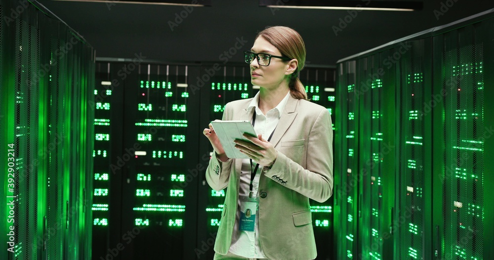 Caucasian beautiful woman in glasses walking at servers with tablet ...