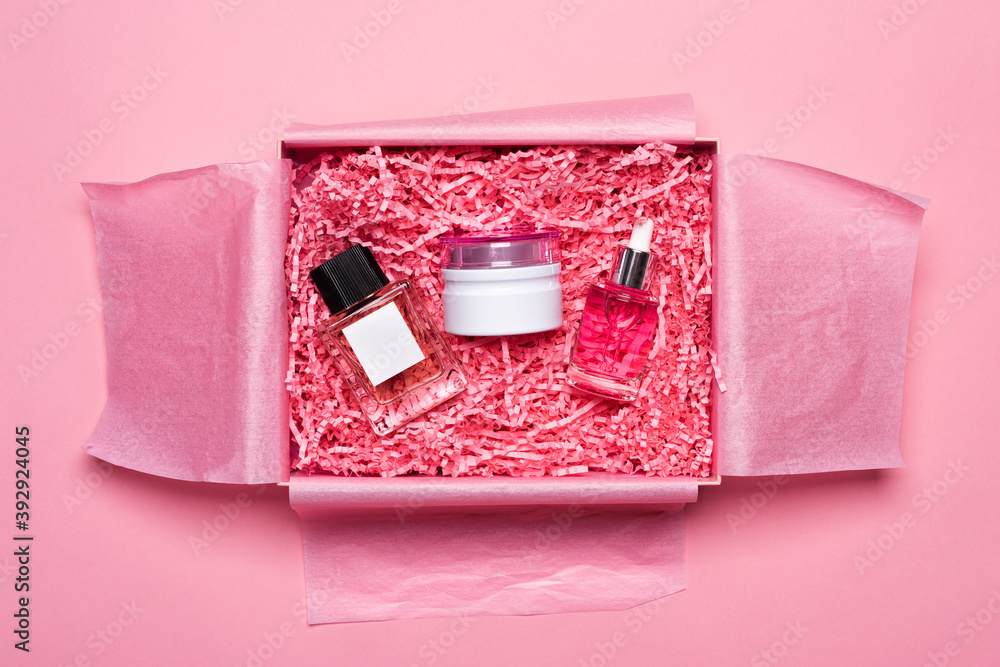 Beauty box with cosmetics filled with shredded pink paper packing ...